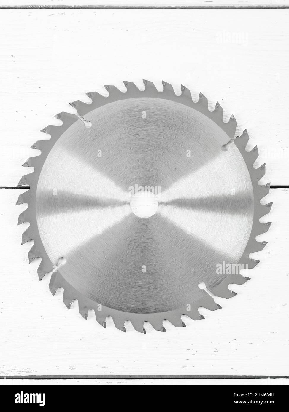Metal circular saw disc on a white wooden background Stock Photo - Alamy