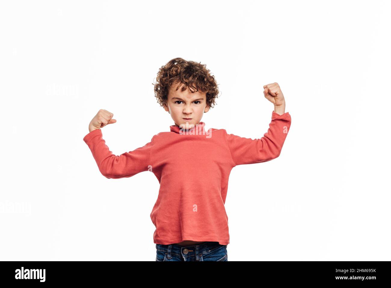Angry young boy raising both arms with clenched fists to showing his ...