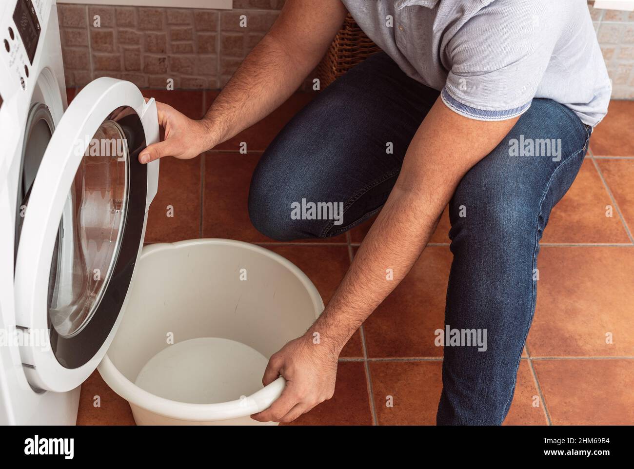 A latin man opening washing machine door Stock Photo - Alamy