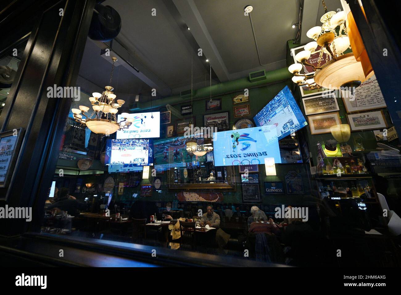 Multiple TV screens broadcast the Beijing 2022 Winter Olympics inside ...