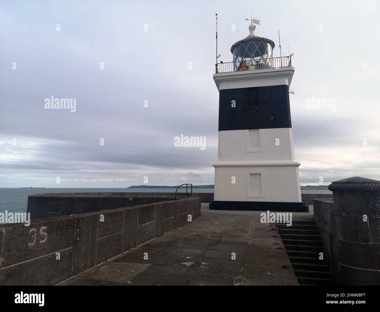 Holyhead Breakwater lighthouse on a concrete pier on a gloomy day Stock ...