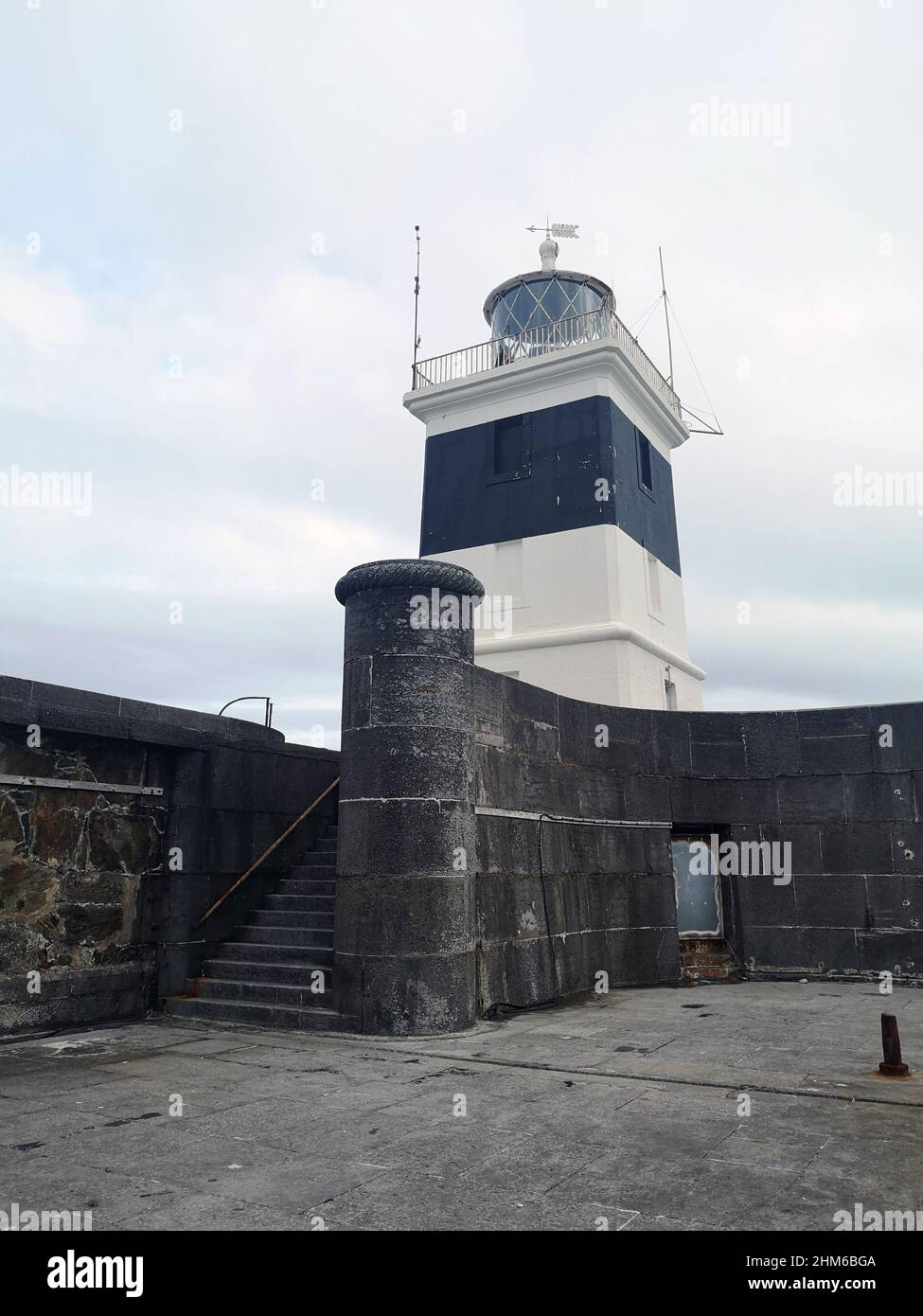 Vertical shot of the Holyhead Breakwater lighthouse on a concrete pier ...