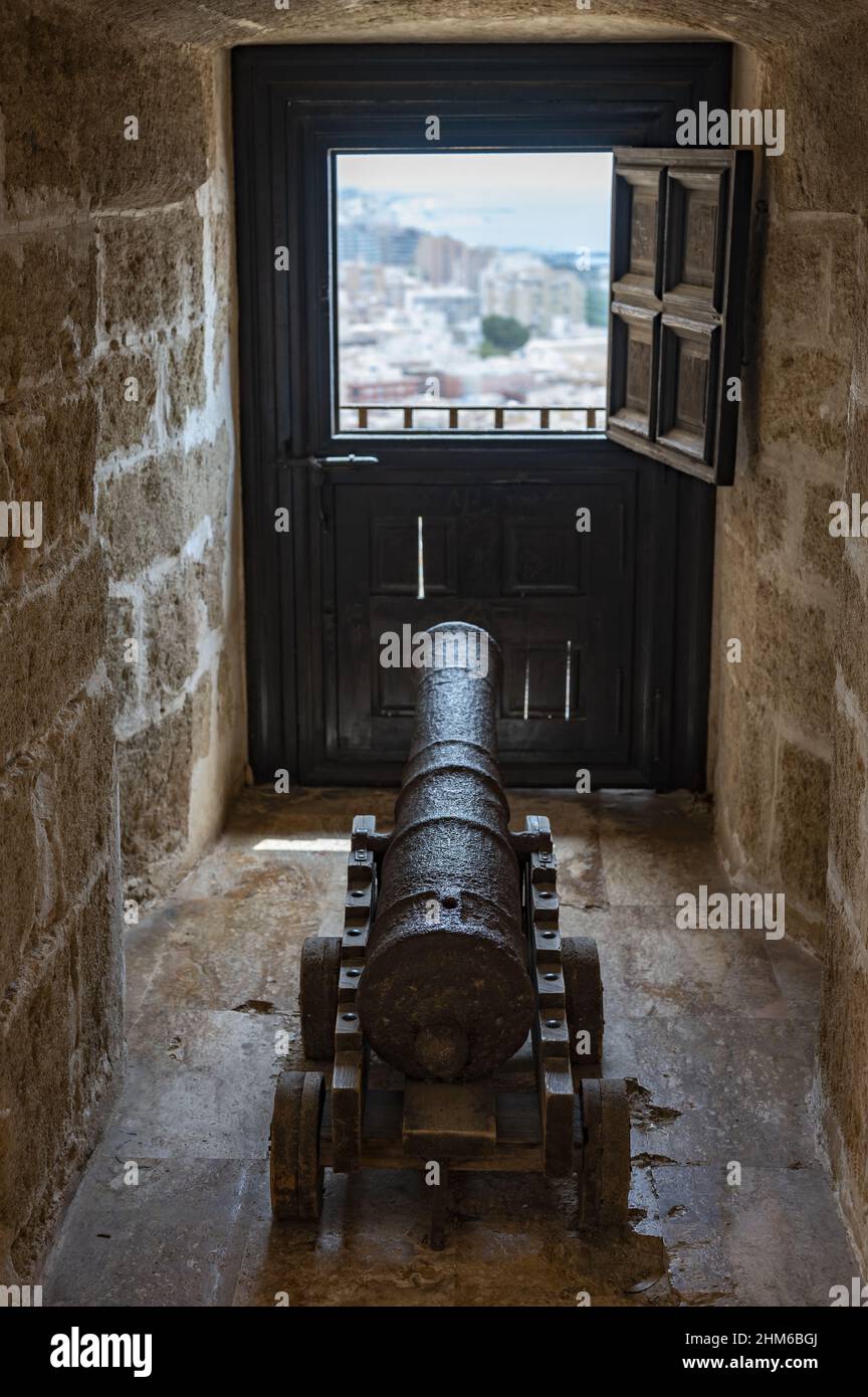 Defense cannon facing the window inside of an old castle of the ...
