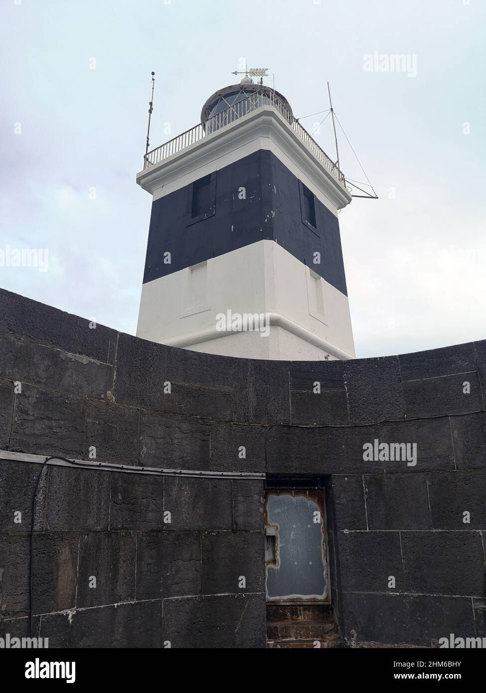 Vertical shot of the Holyhead Breakwater lighthouse on a concrete pier ...