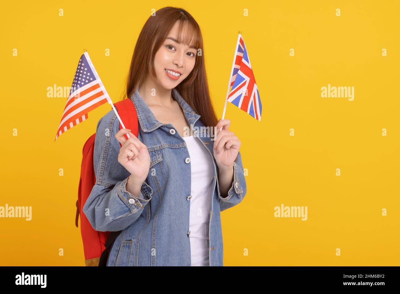 Happy Beautiful girl exchange student holding countries flags and ... Happy Beautiful girl exchange student holding countries flags and ...