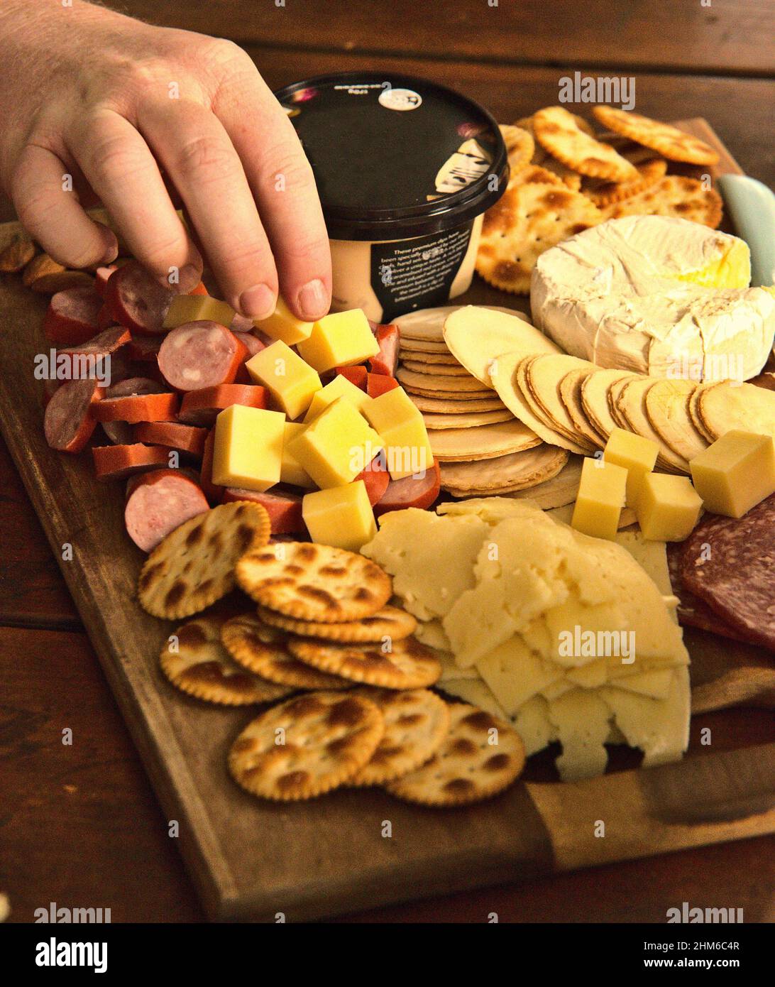 Wooden platter covered in cheese and sausages Stock Photo - Alamy