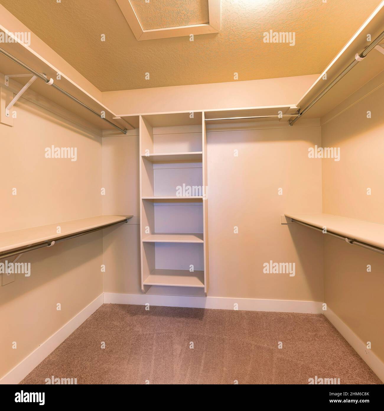 Square Empty walk-in closet with warm color lighting and shelving units ...