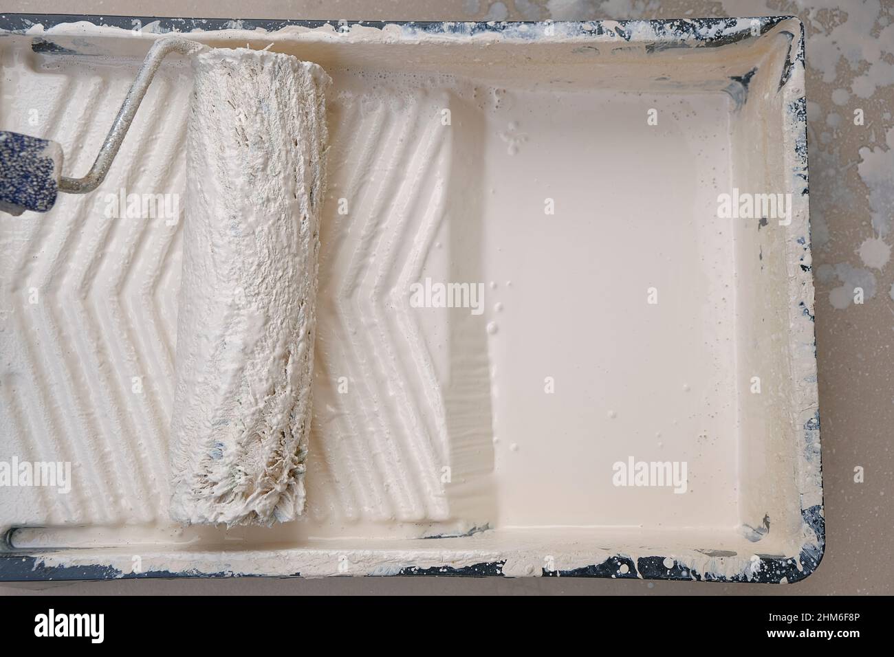 Roller and paint. roller in a container with beige paint.House painting ...