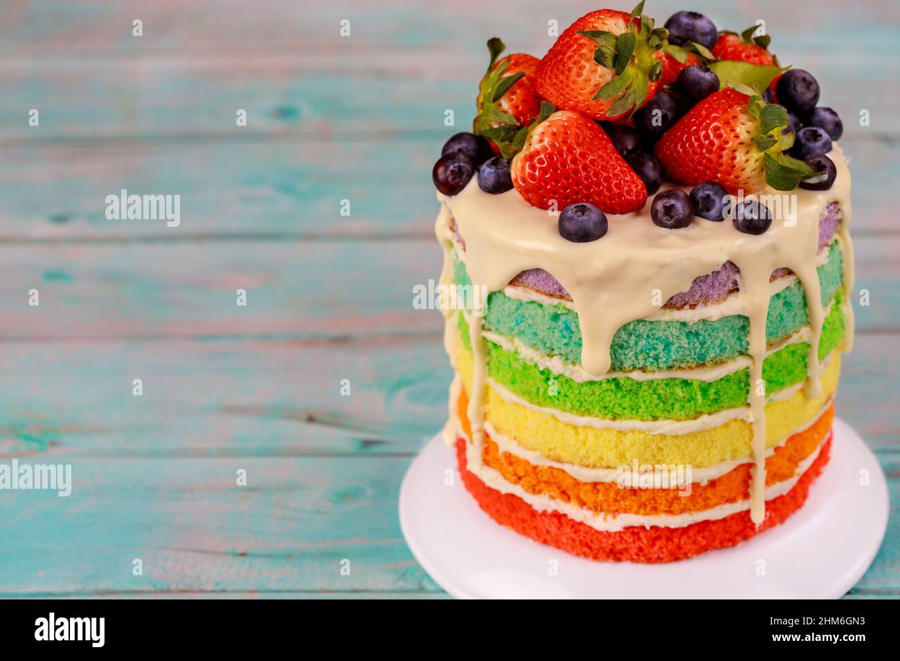 Festive multi layered cake with fresh strawberry. Birthday rainbow cake ...