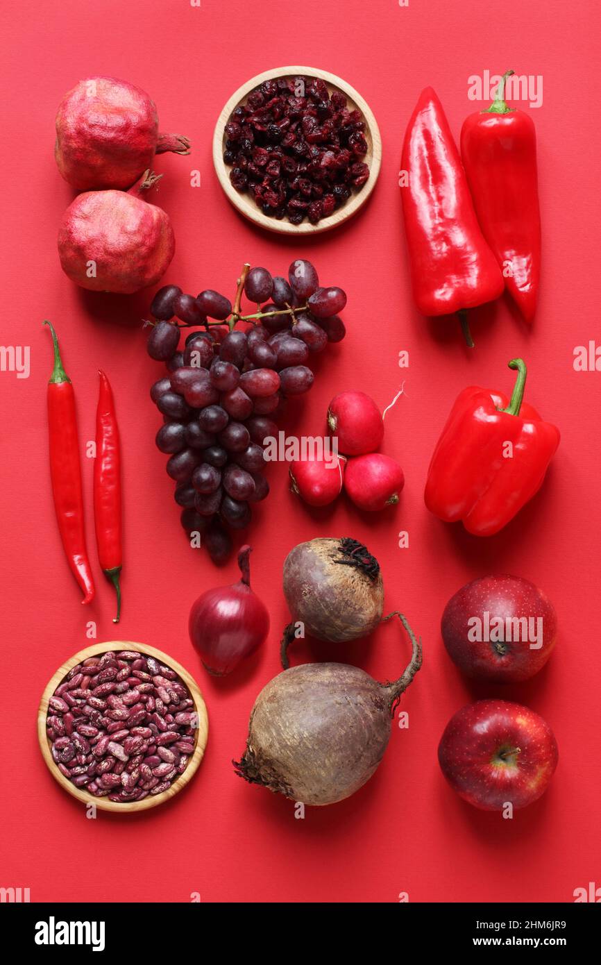 Red fruits and vegetables on a red background. Pomegranates, dried ...