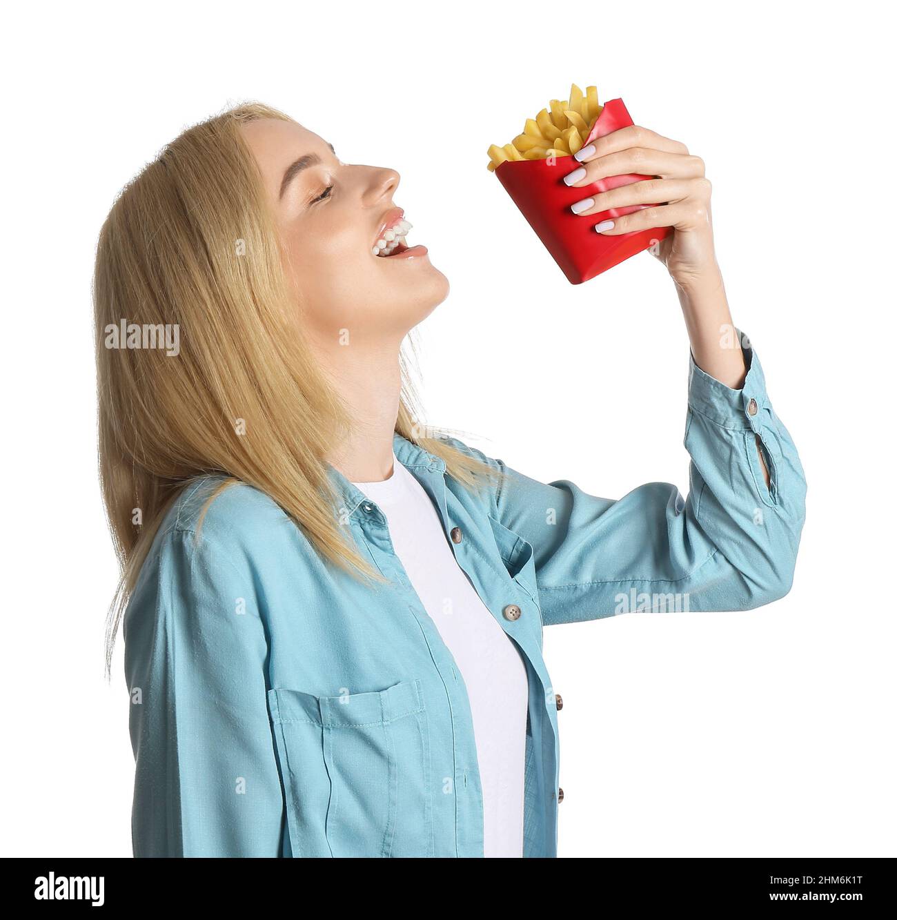 Young woman eating french fries on white background Stock Photo - Alamy