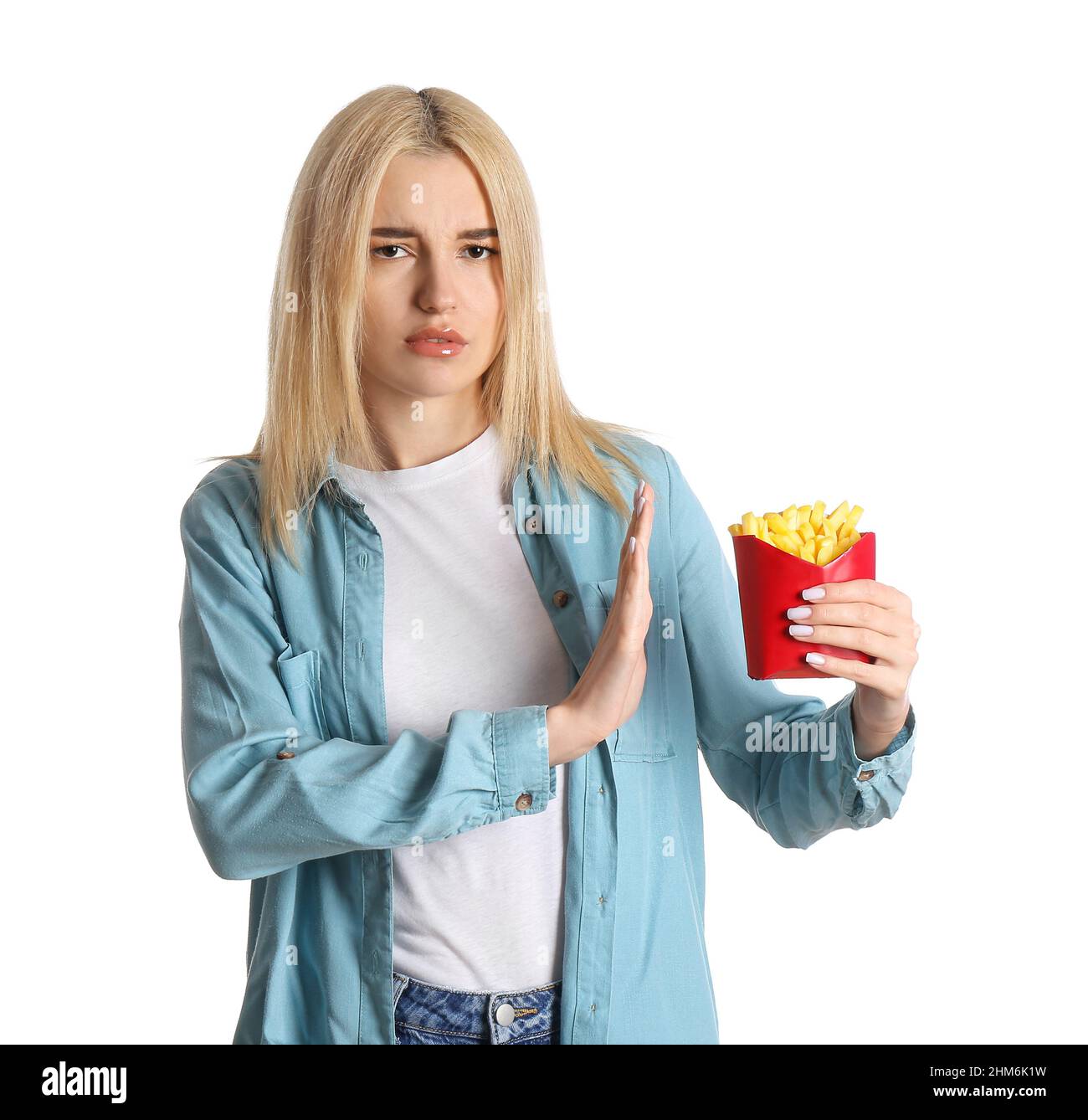 Beautiful young woman refusing to eat french fries on white background ...