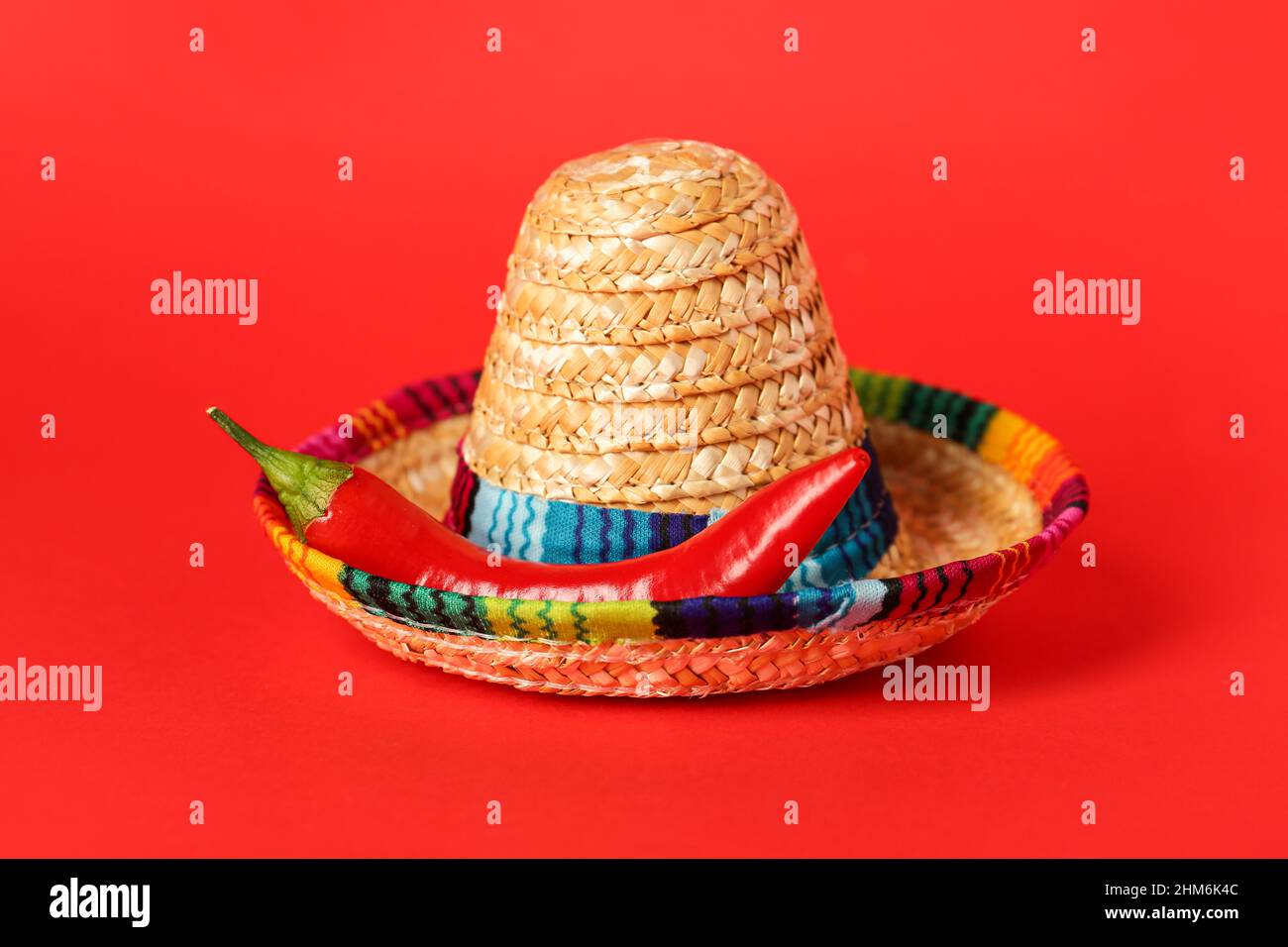 Mexican sombrero and hot chili pepper on red background Stock Photo - Alamy