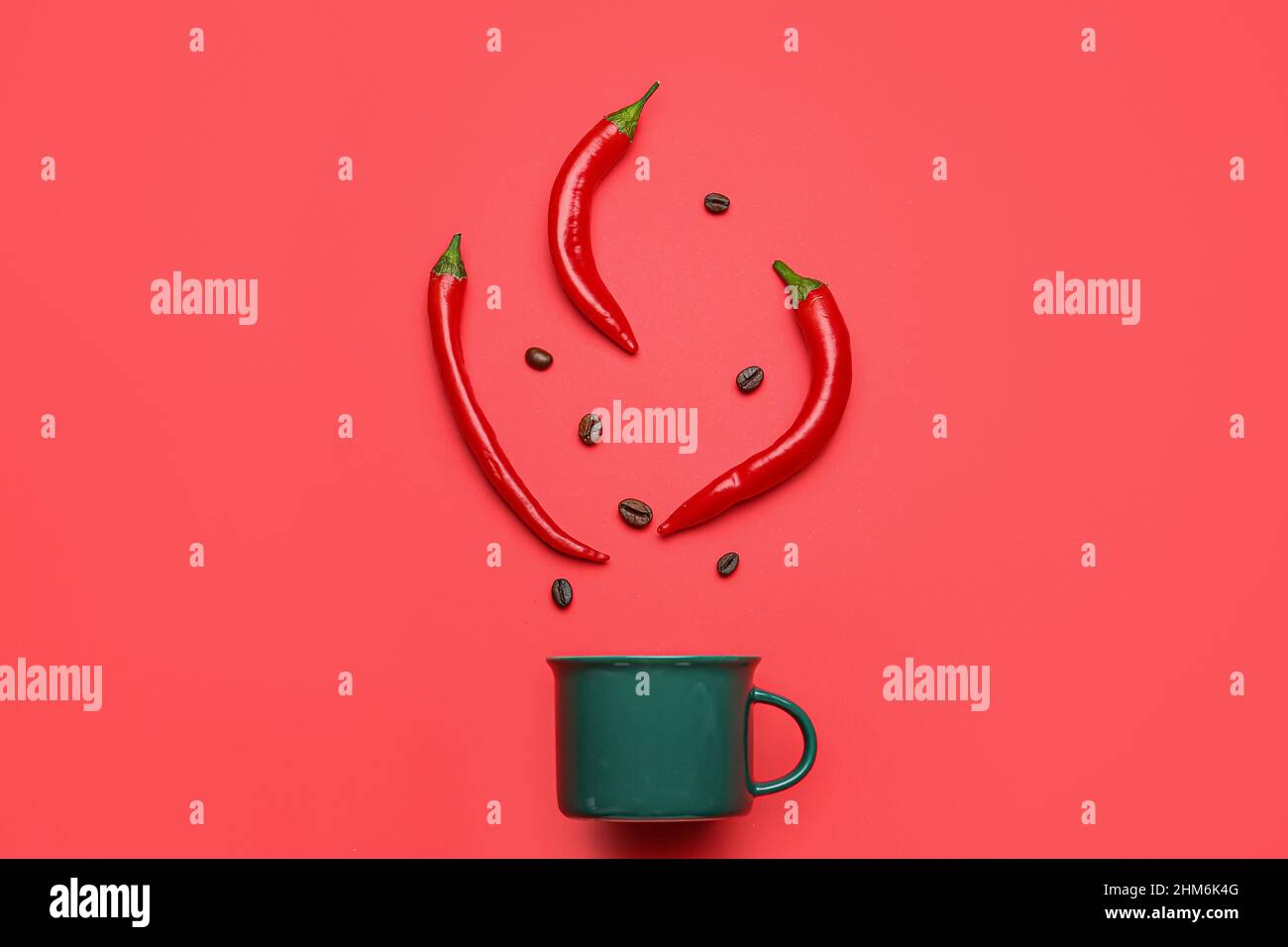 Mug with hot chili peppers and coffee beans on red background Stock ...