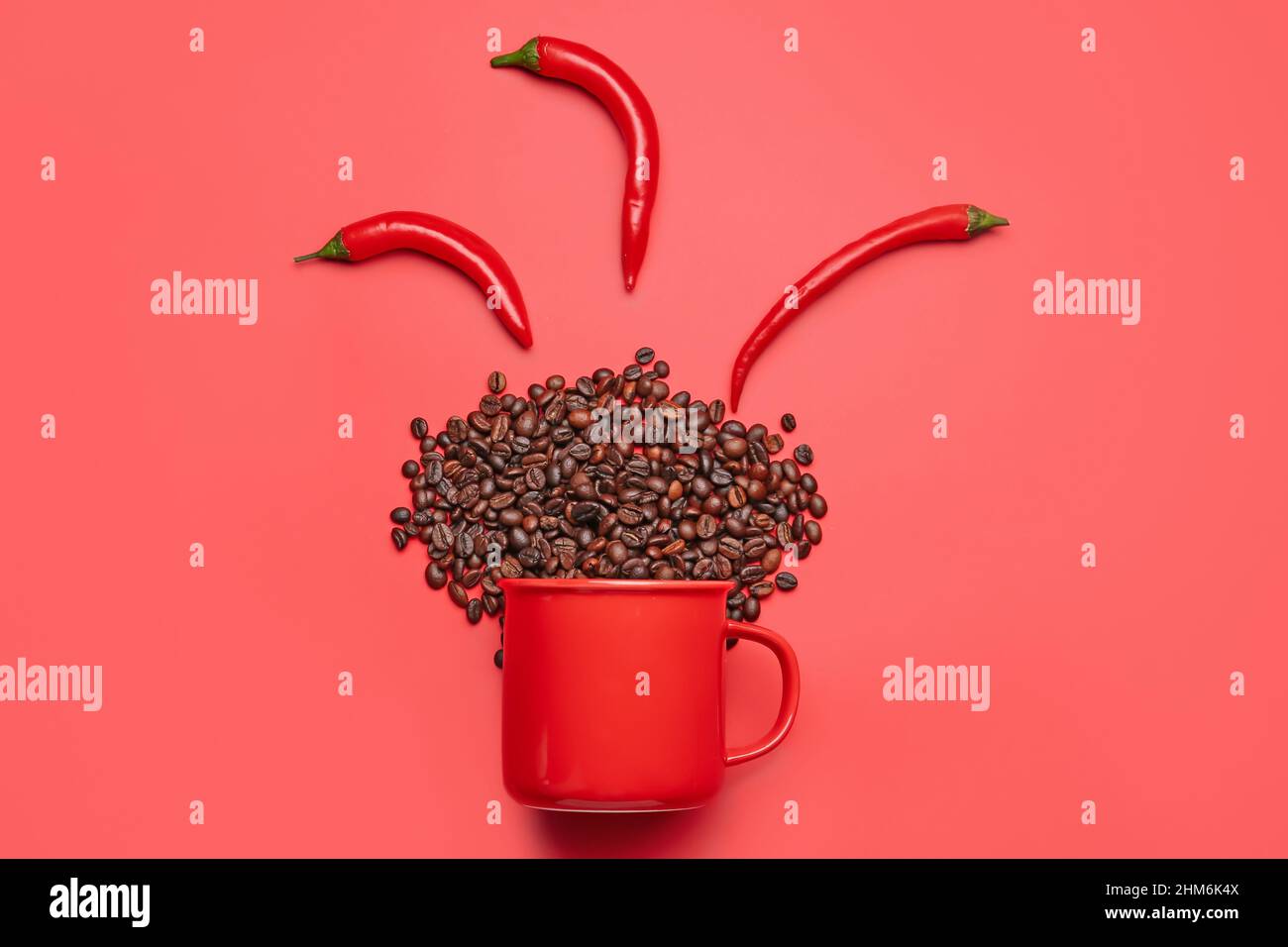 Mug with hot chili peppers and coffee beans on red background Stock ...