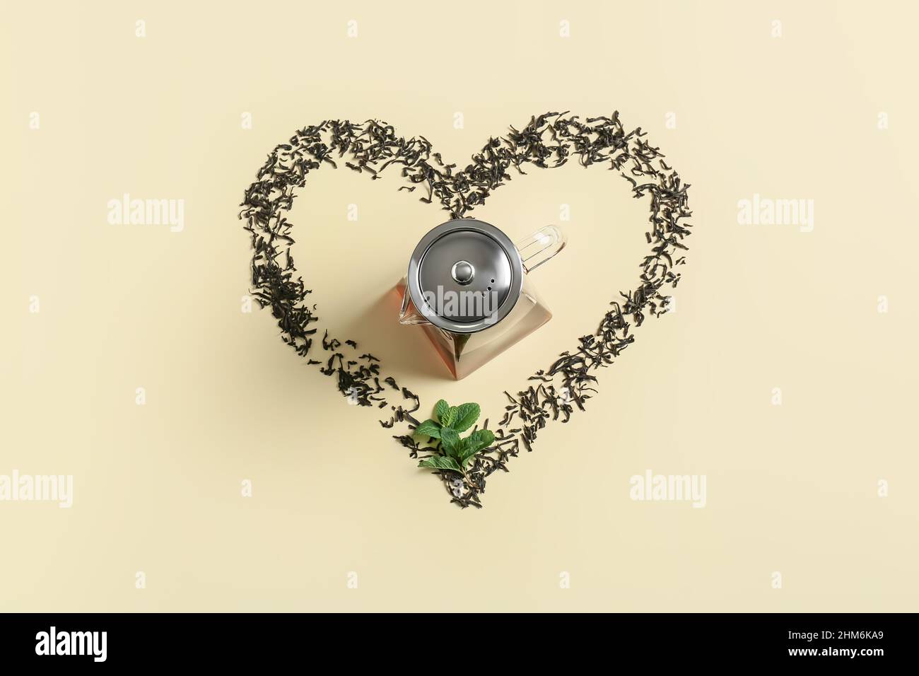 Heart shape made of tea and teapot on yellow background Stock Photo - Alamy