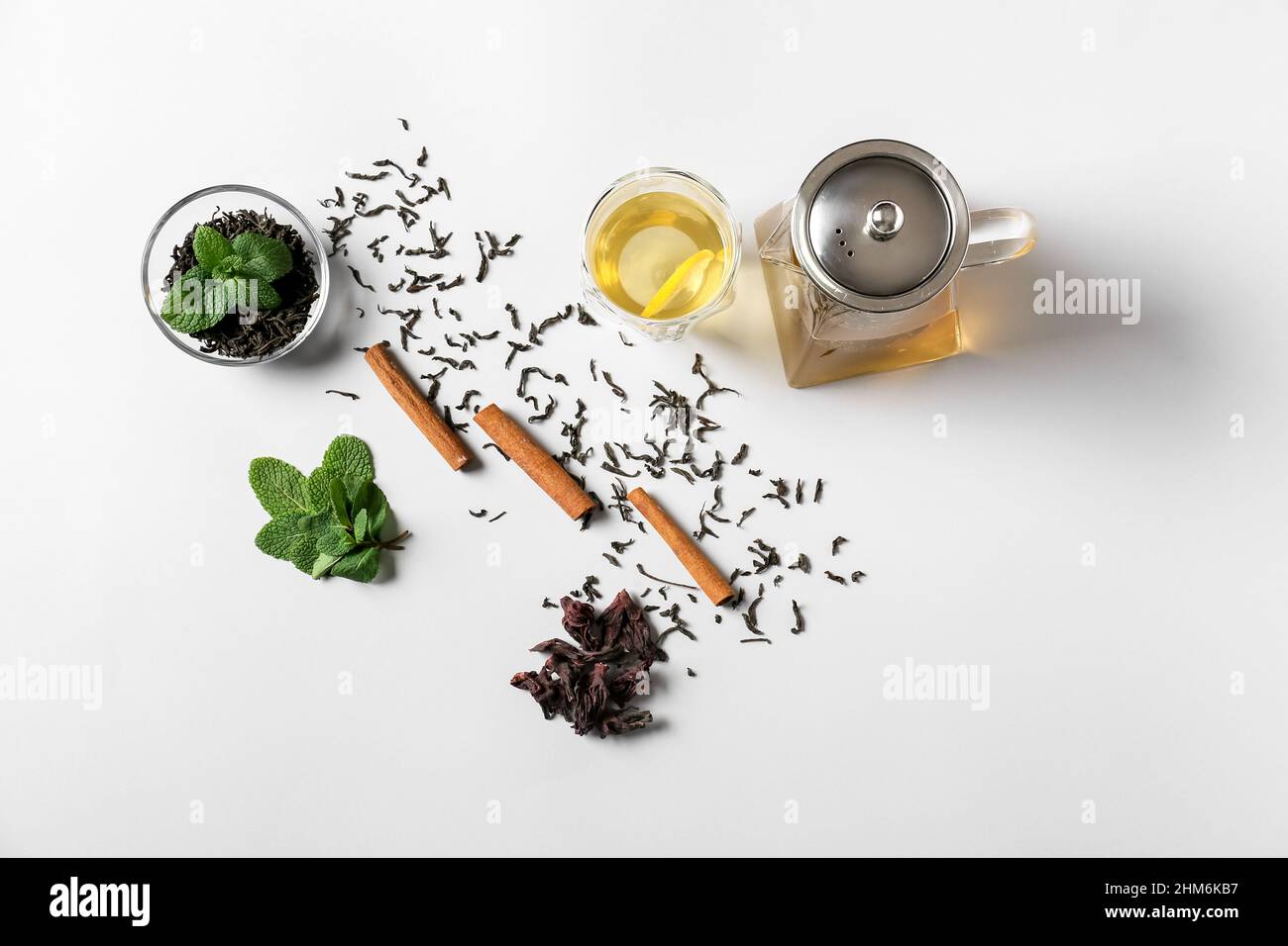 Composition of teapot and glass with tasty tea on light background ...