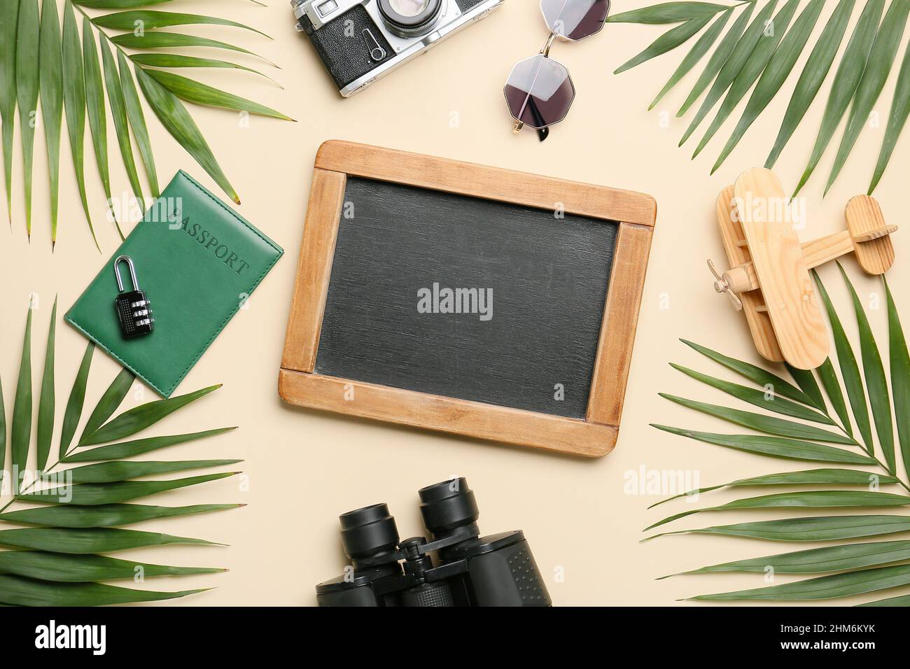 Composition with blank chalkboard, travel items and palm leaves on ...