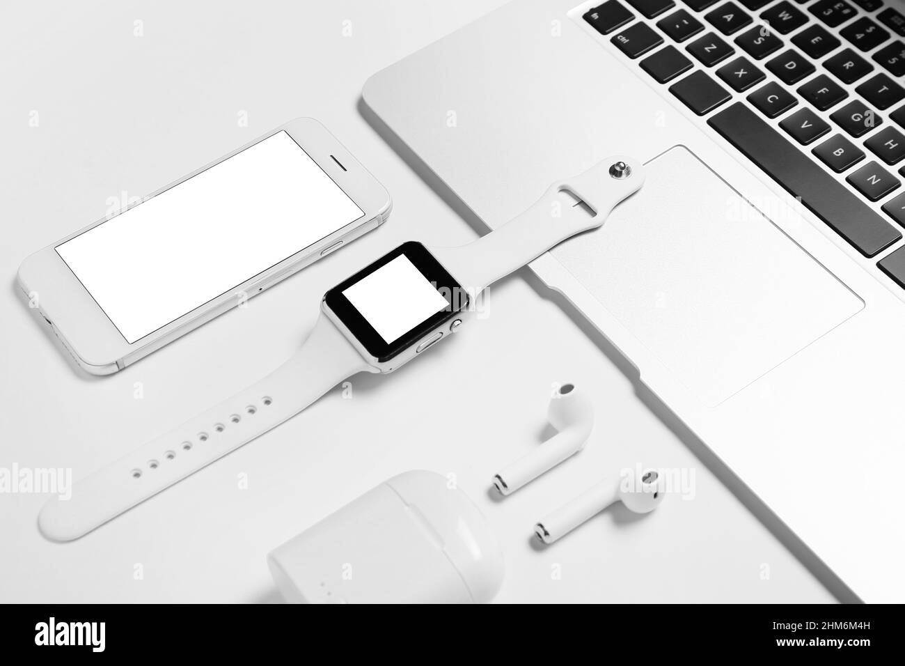 Mobile phone, smart watch, earphones and laptop on white background ...