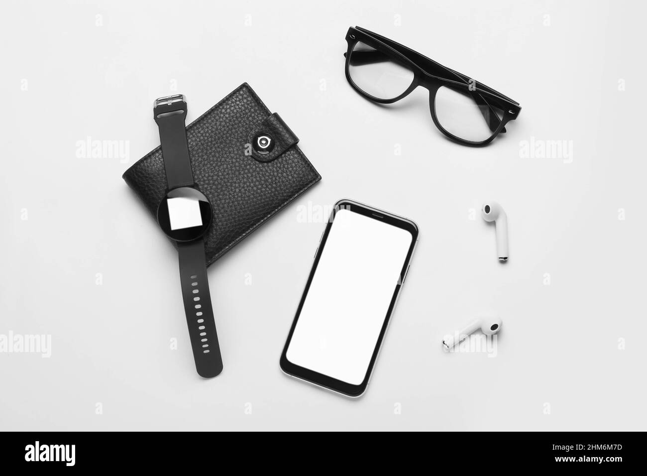 Mobile phone, smart watch, earphones, wallet and eyeglasses on white ...