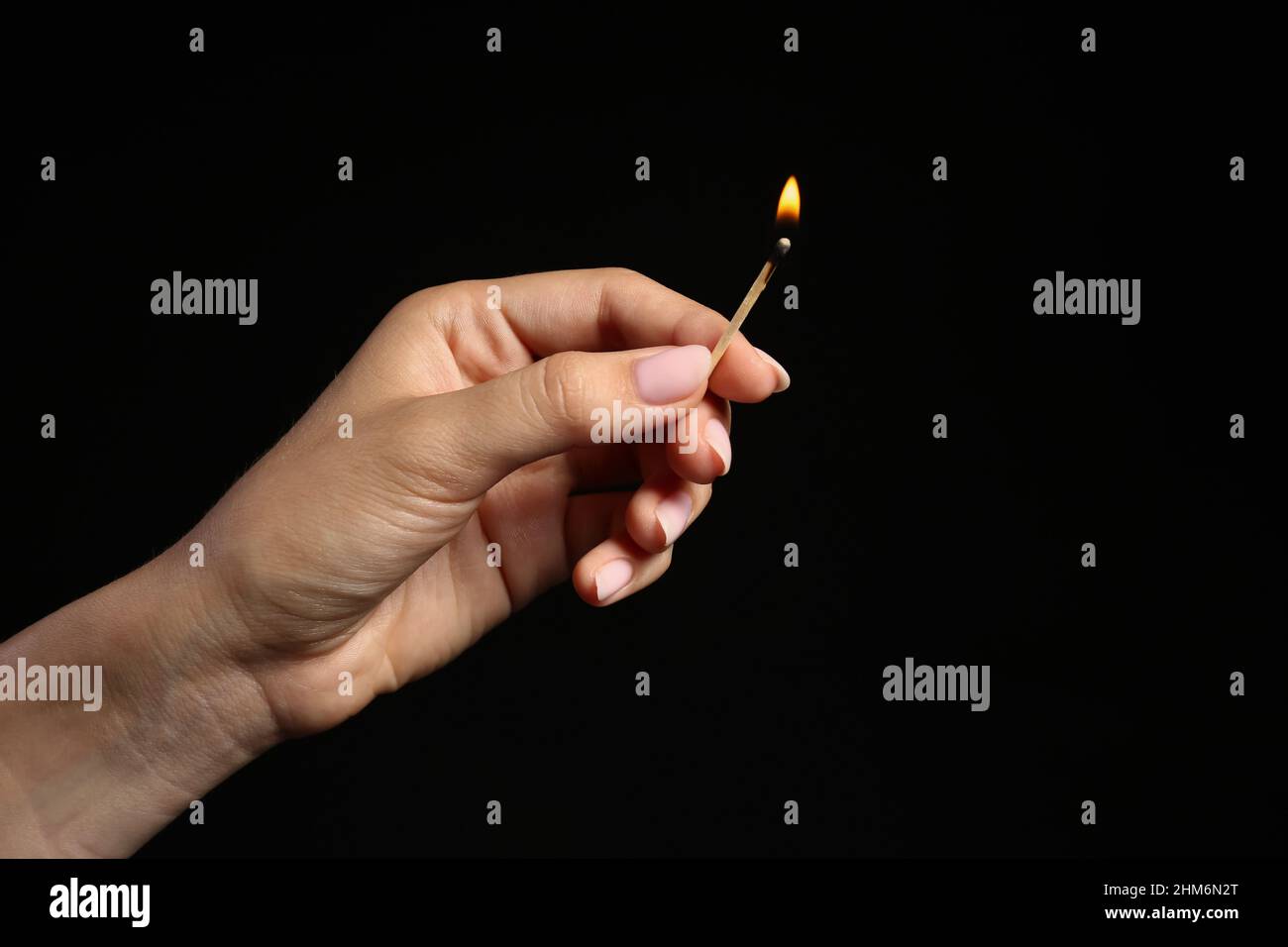 Female hand with burning match on black background Stock Photo - Alamy
