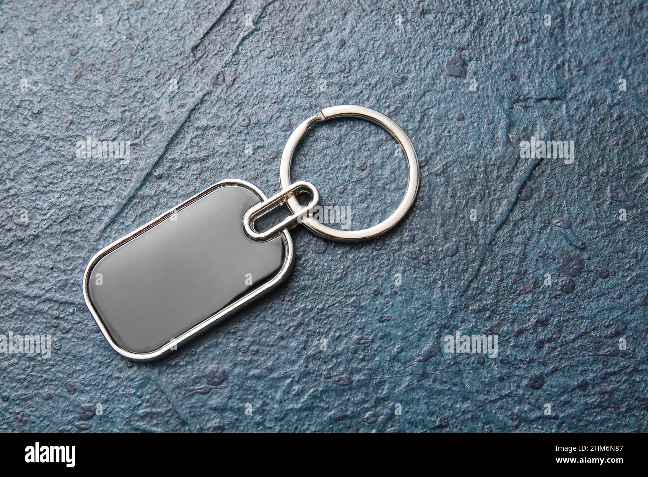 Stylish metallic keychain on dark background Stock Photo - Alamy