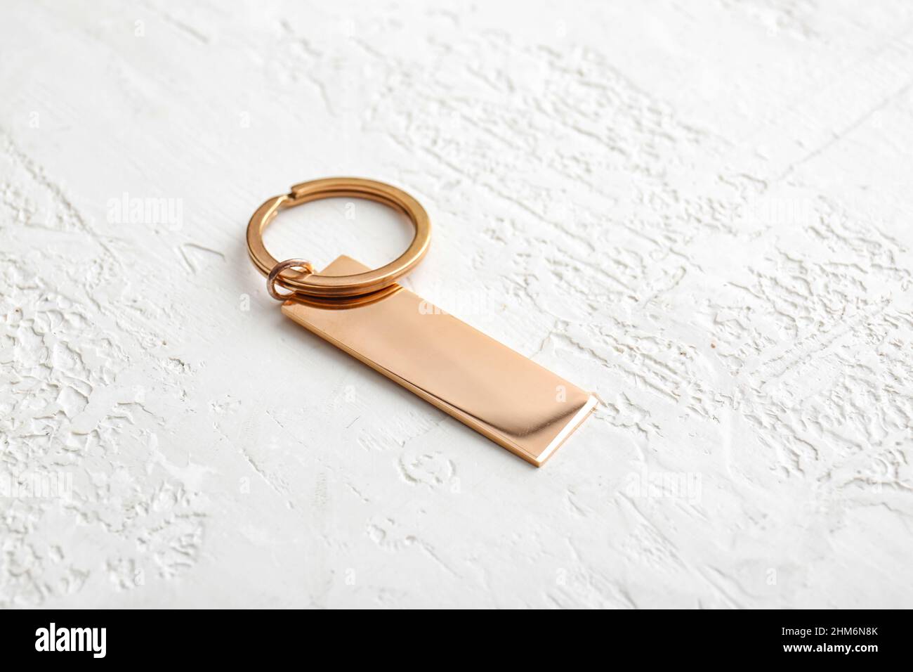 Stylish bronze keychain on white background Stock Photo - Alamy