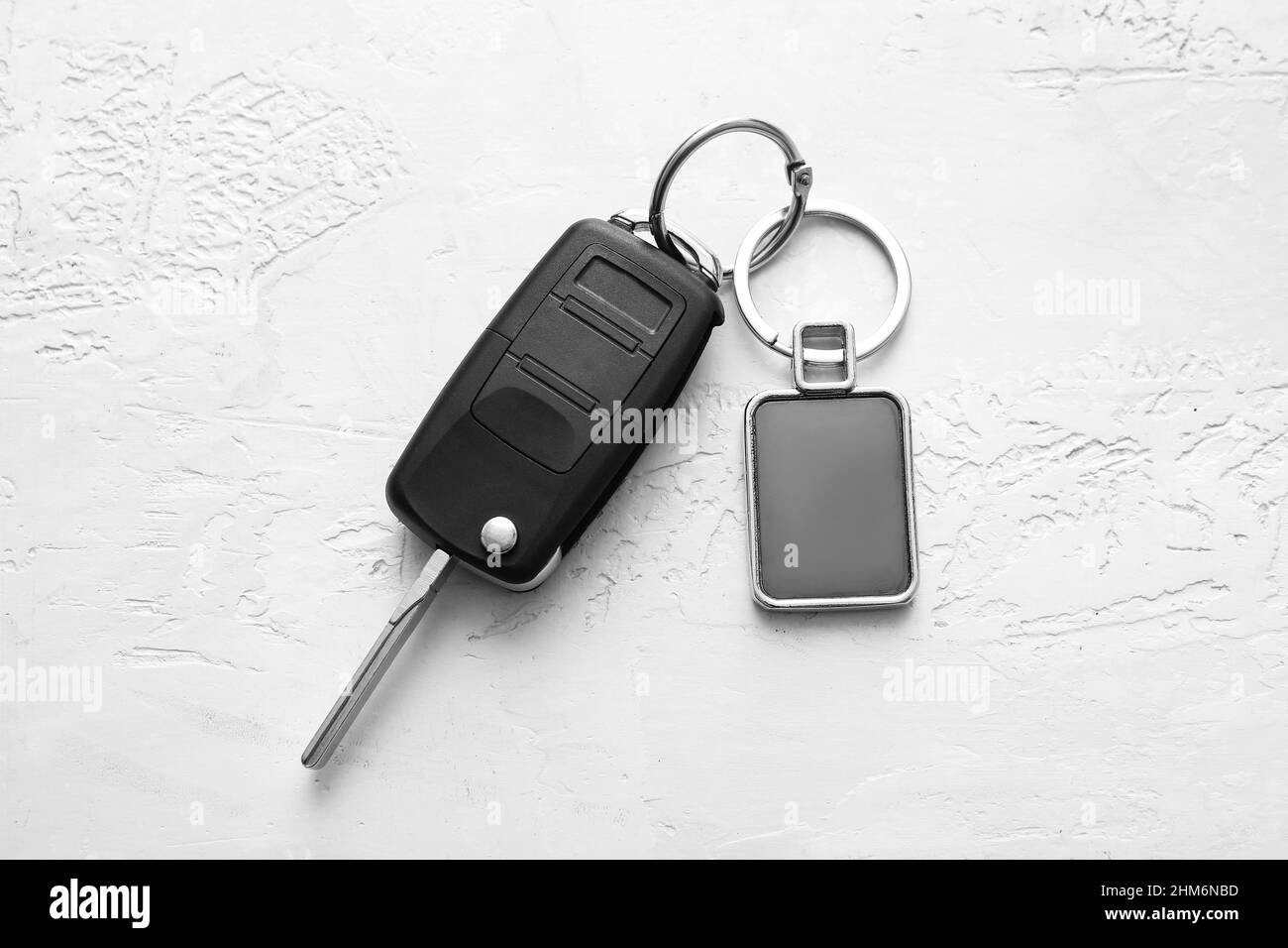 Car key with stylish keychain on white background Stock Photo - Alamy