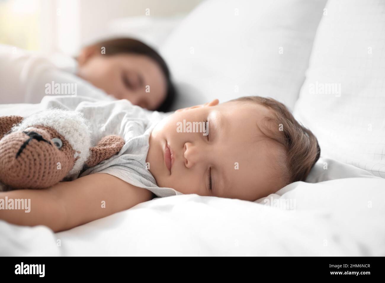 Adorable baby with toy sleeping on bed, closeup Stock Photo - Alamy