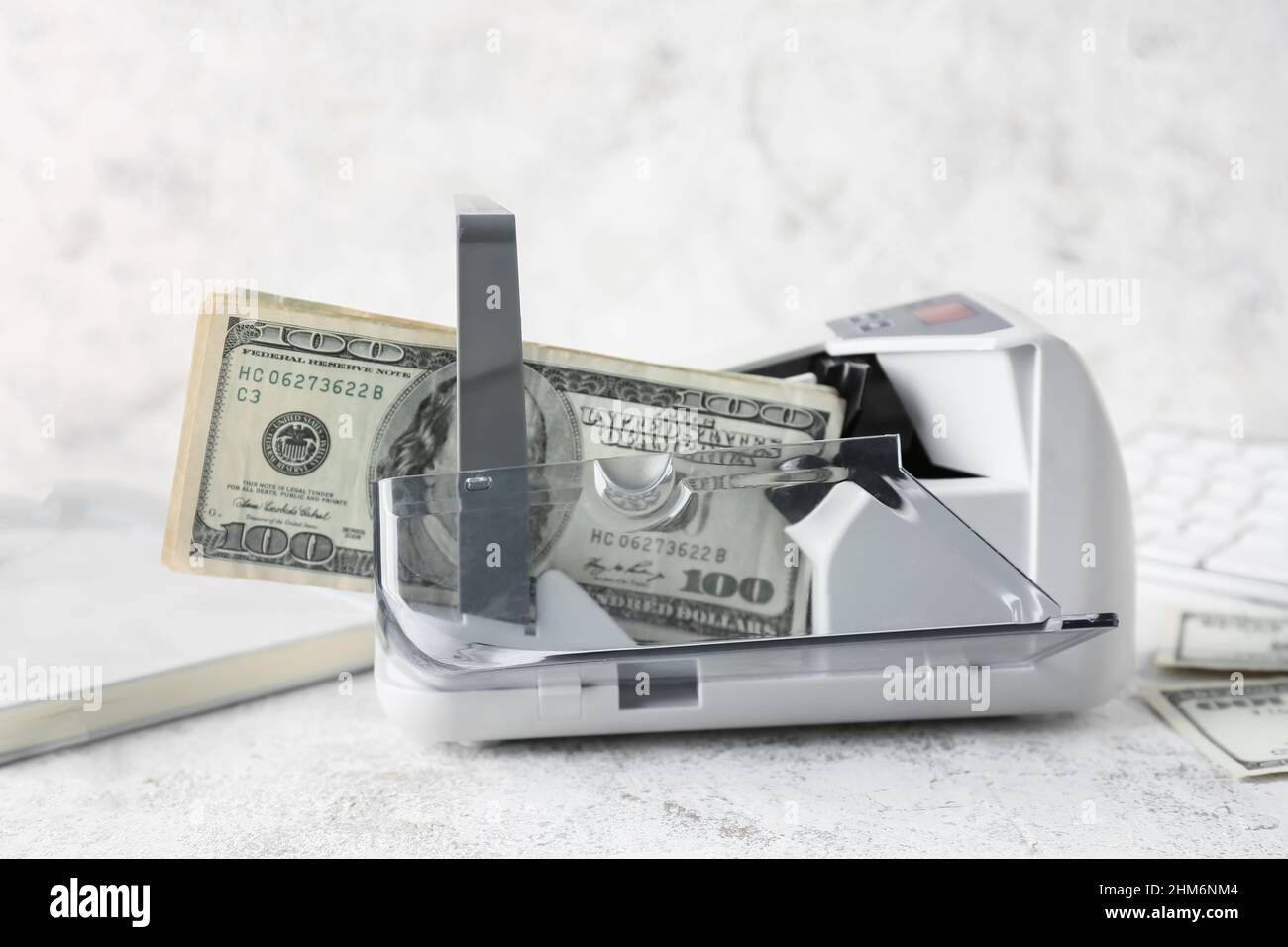 Money in currency counting machine on light background Stock Photo - Alamy