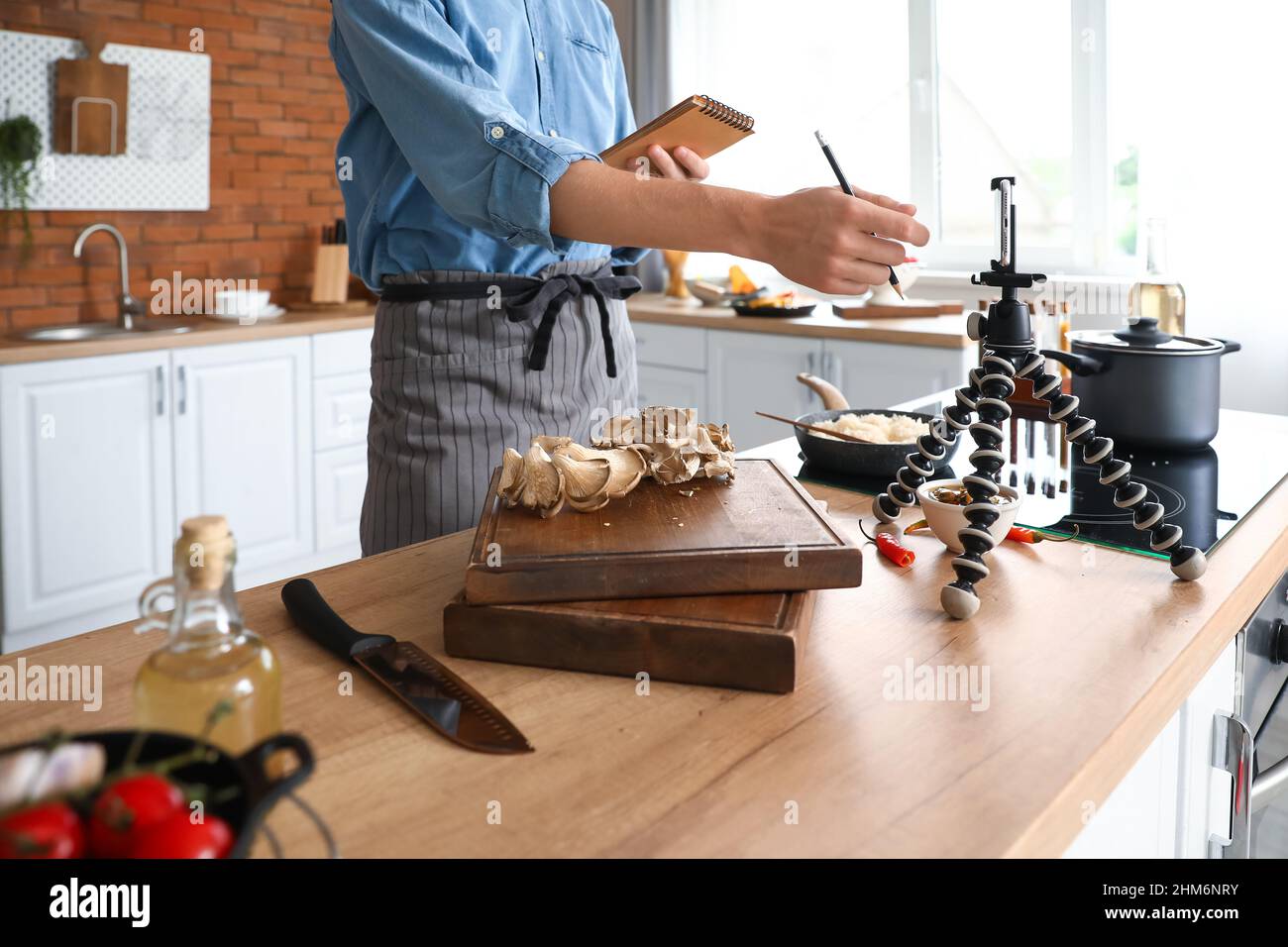 Young man making notes from cooking video tutorial in kitchen Stock ...