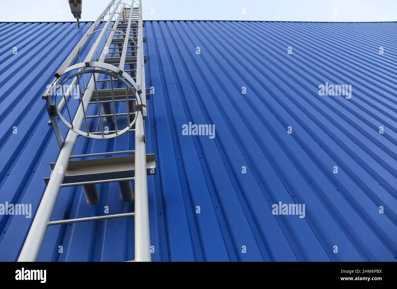 Fire escape metal ladder of blue building outdoors Stock Photo - Alamy