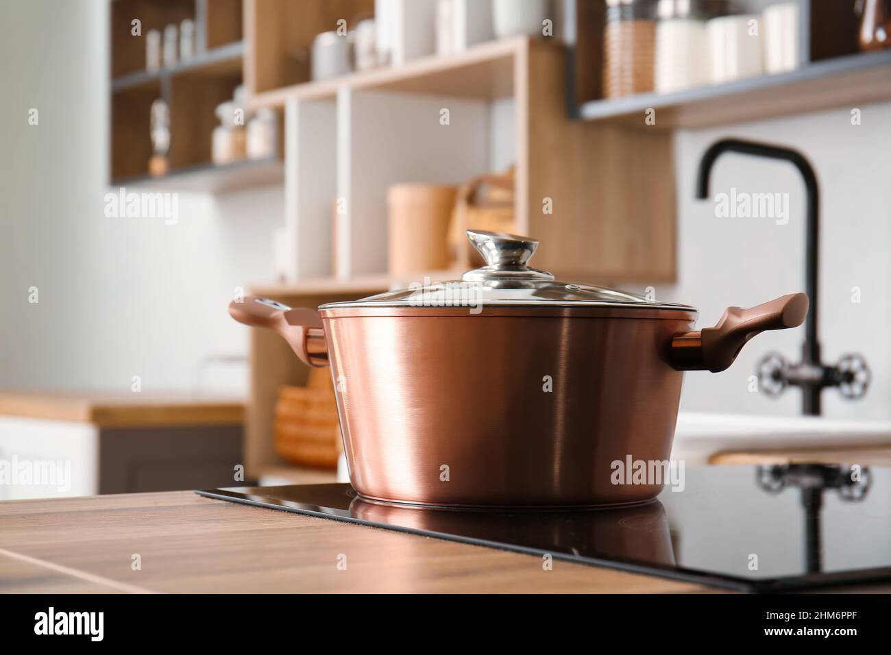 Shiny cooking pot on stove in light kitchen Stock Photo - Alamy
