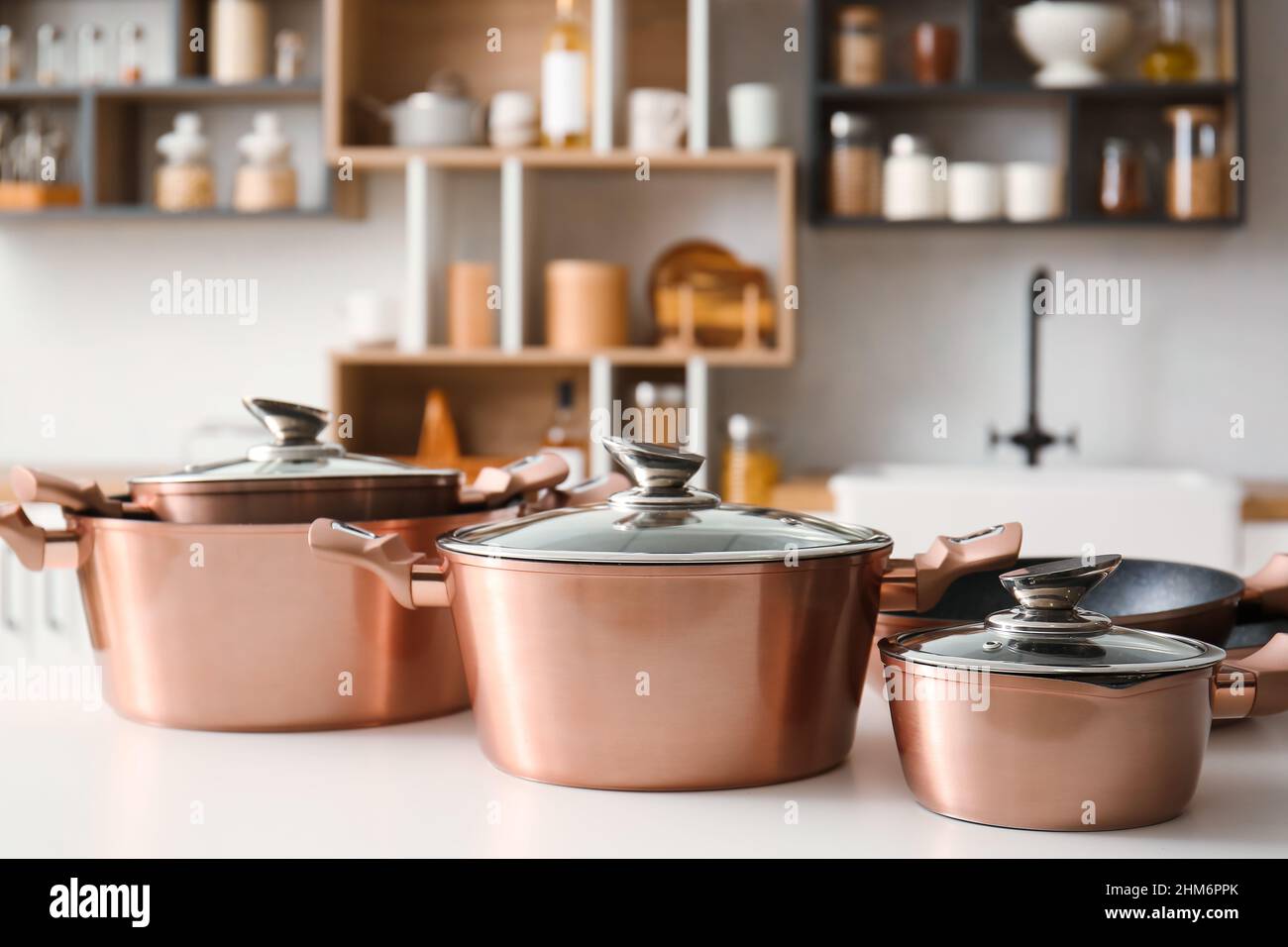 Shiny cooking pots on table in light kitchen Stock Photo - Alamy