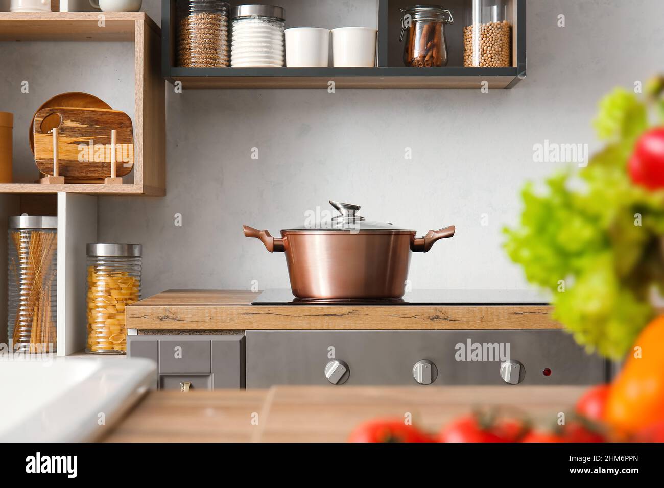 Shiny cooking pot on stove in modern kitchen Stock Photo - Alamy