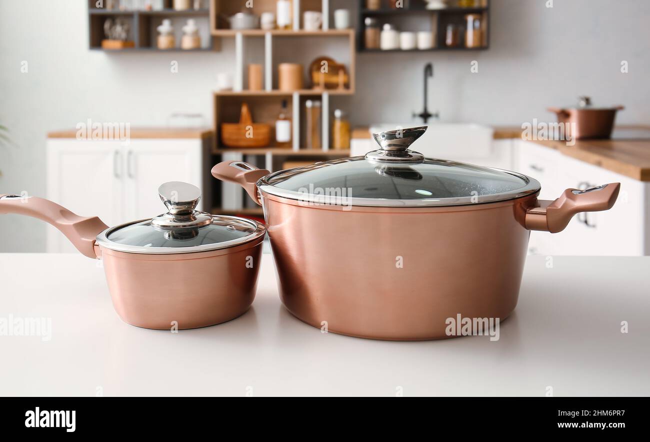 Shiny cooking pots on table in light kitchen Stock Photo - Alamy