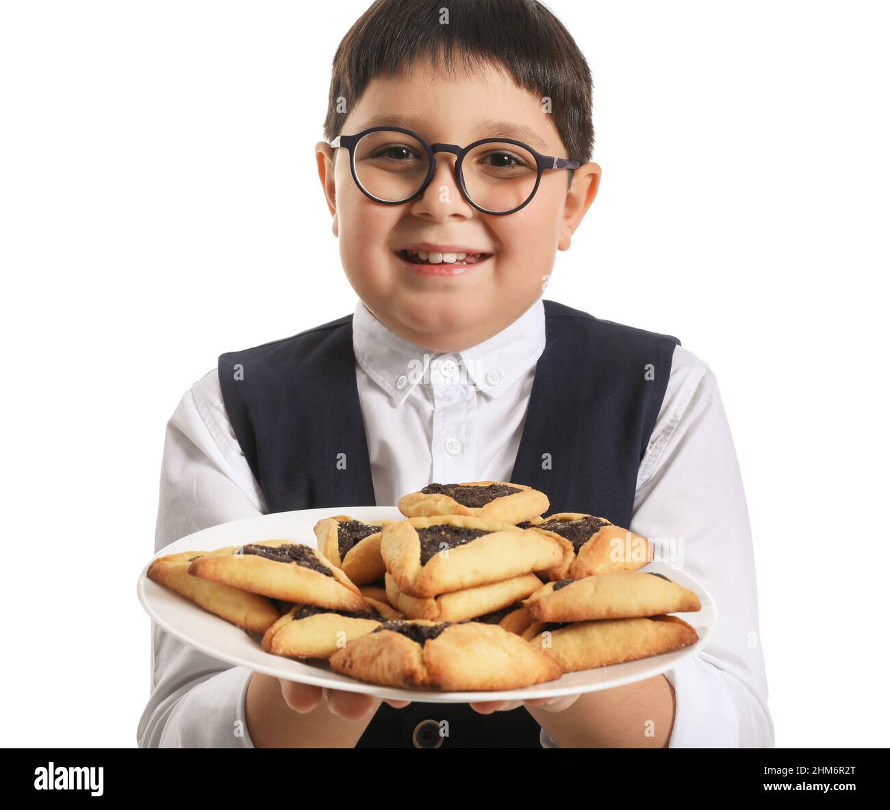 Little Jewish boy with tasty Hamantaschen for Purim holiday on white ...