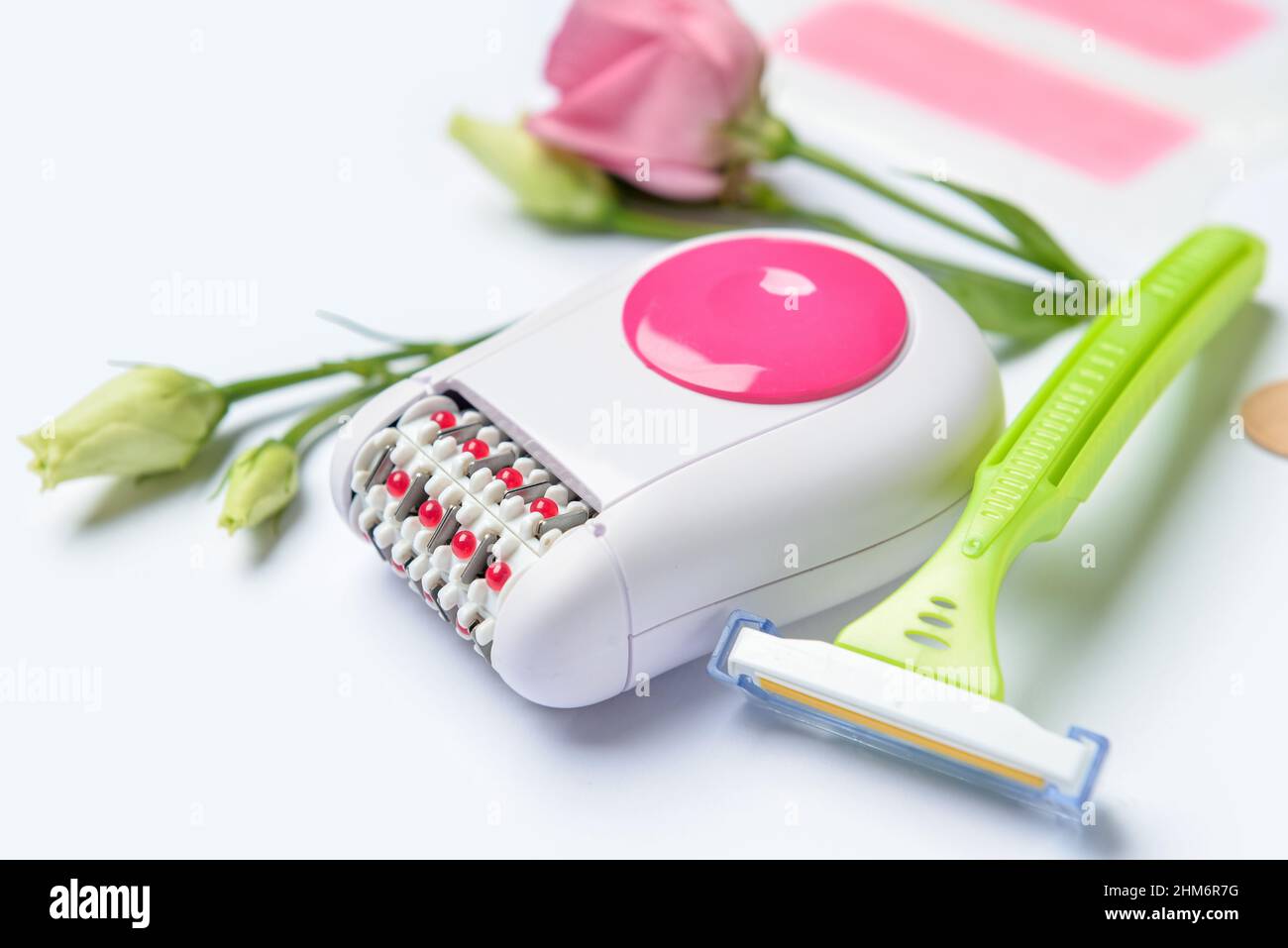 Modern epilator, flowers and razor on white background Stock Photo - Alamy