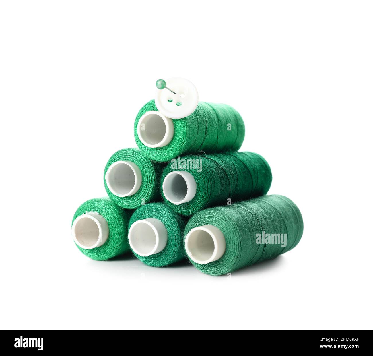 Green sewing threads on white background Stock Photo - Alamy