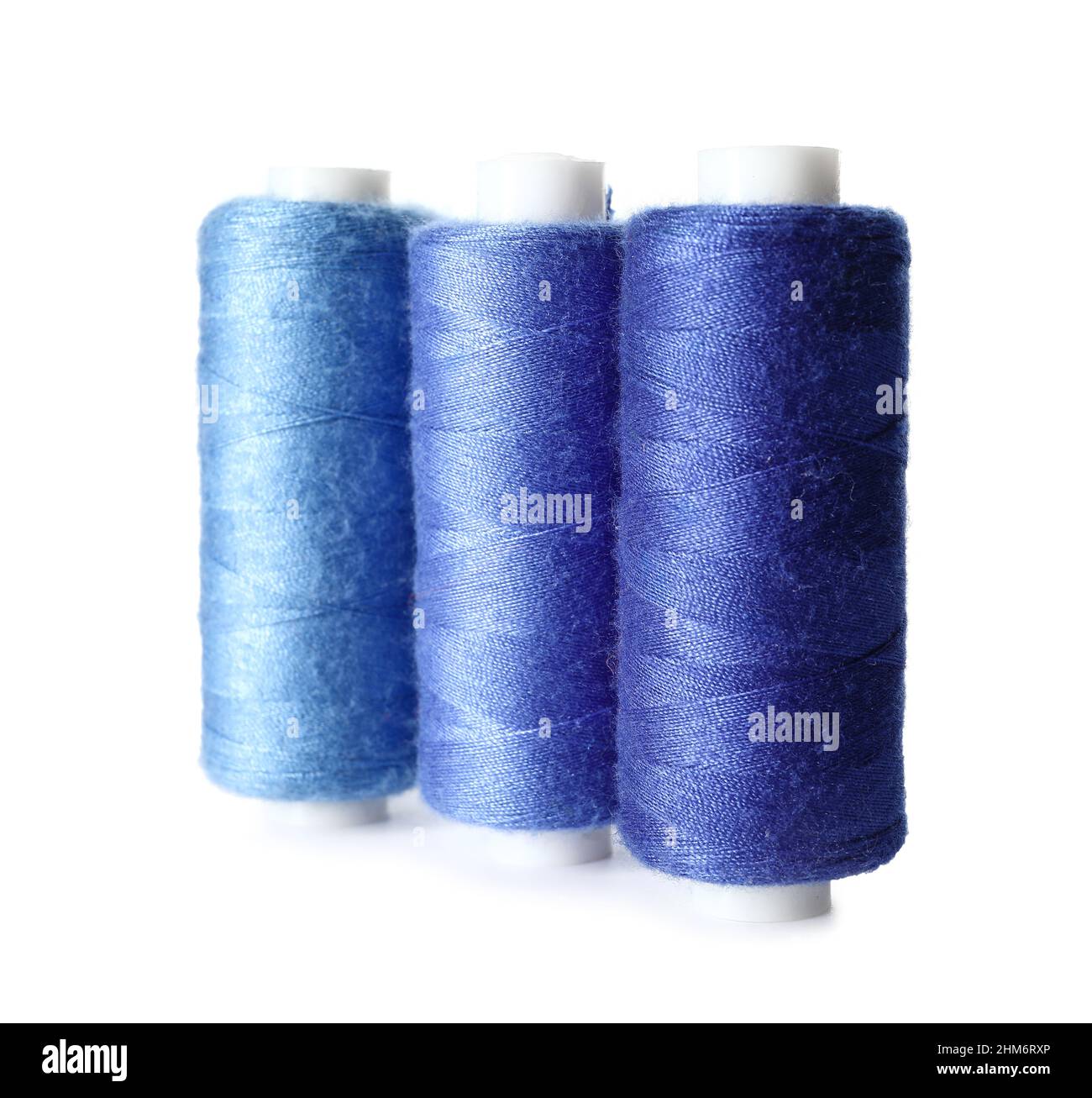 Blue sewing threads on white background Stock Photo - Alamy