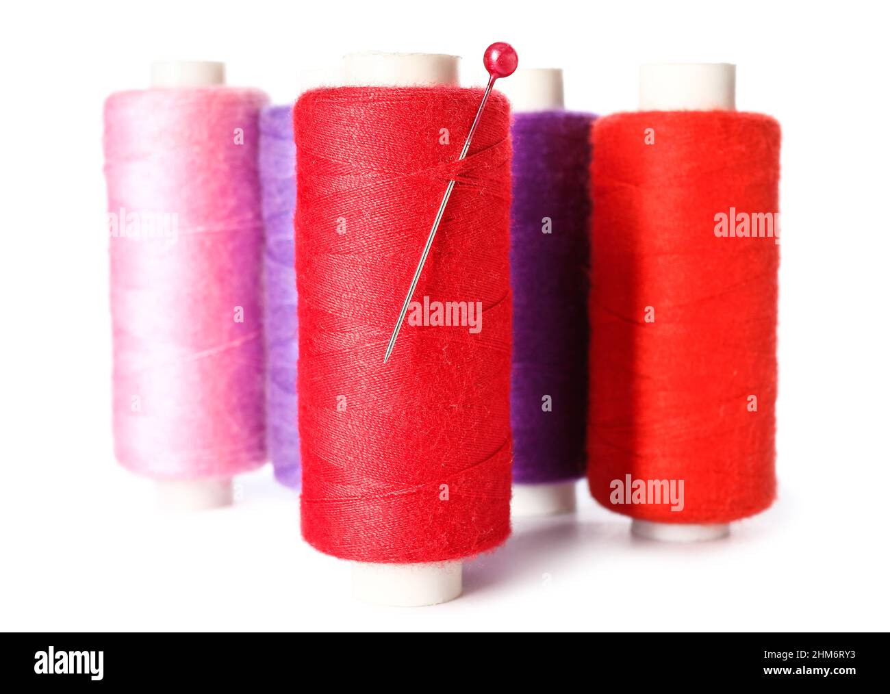 Different sewing threads with needle on white background Stock Photo ...