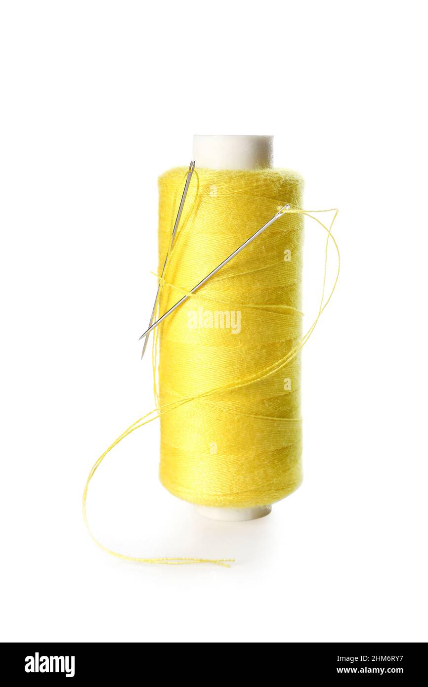 Yellow sewing thread spool on white background Stock Photo - Alamy