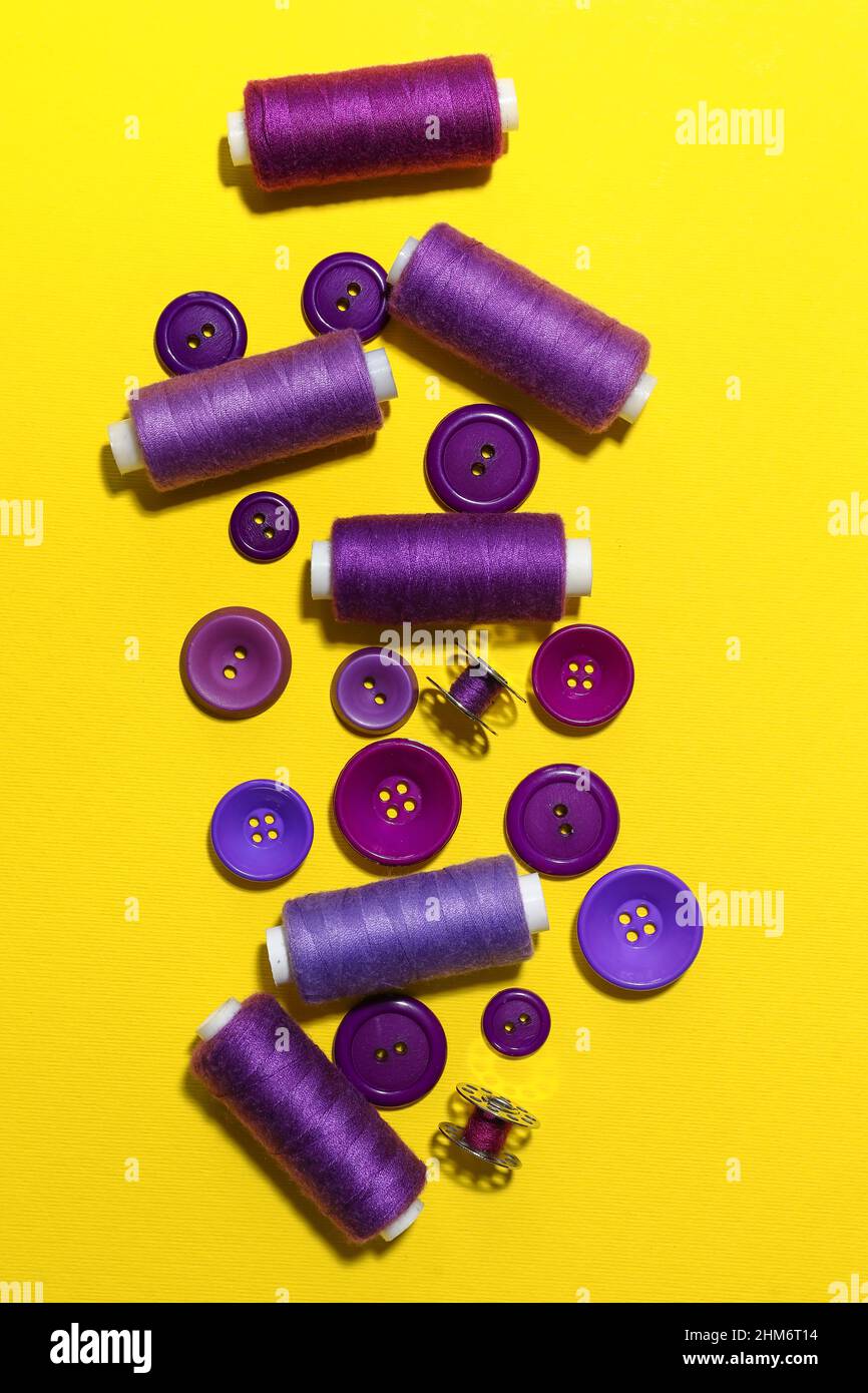 Different sewing threads with buttons on yellow background Stock Photo ...