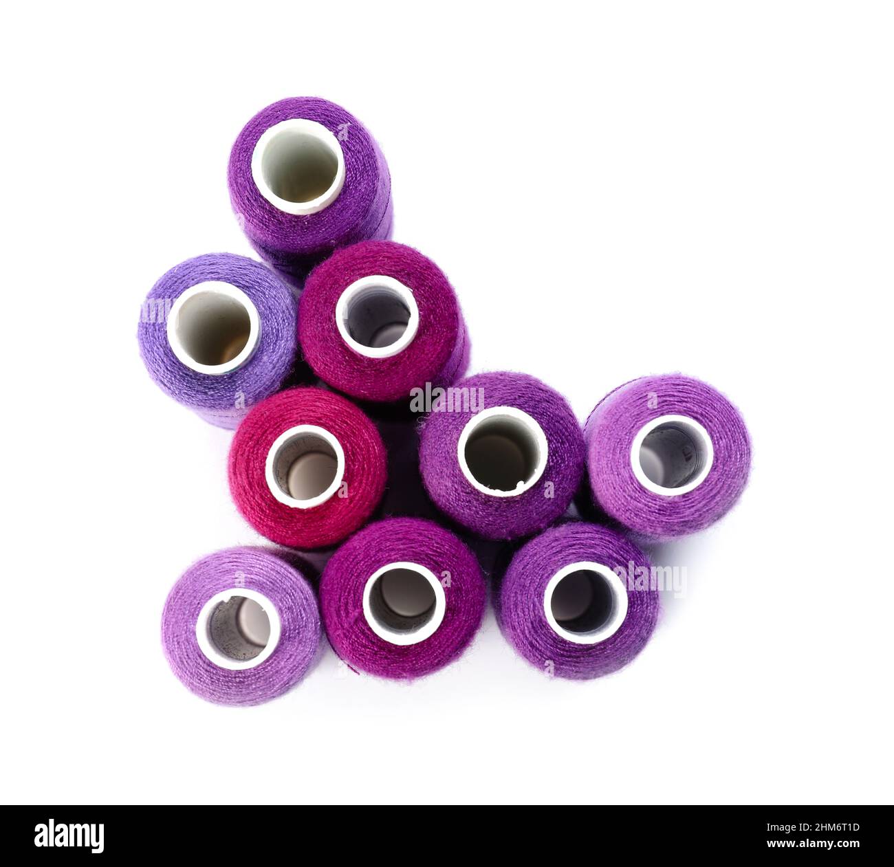 Purple sewing threads on white background Stock Photo - Alamy