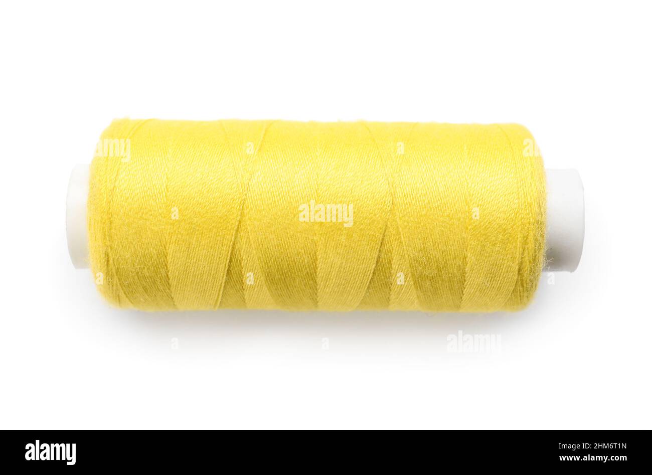 Yellow sewing thread spool on white background Stock Photo - Alamy