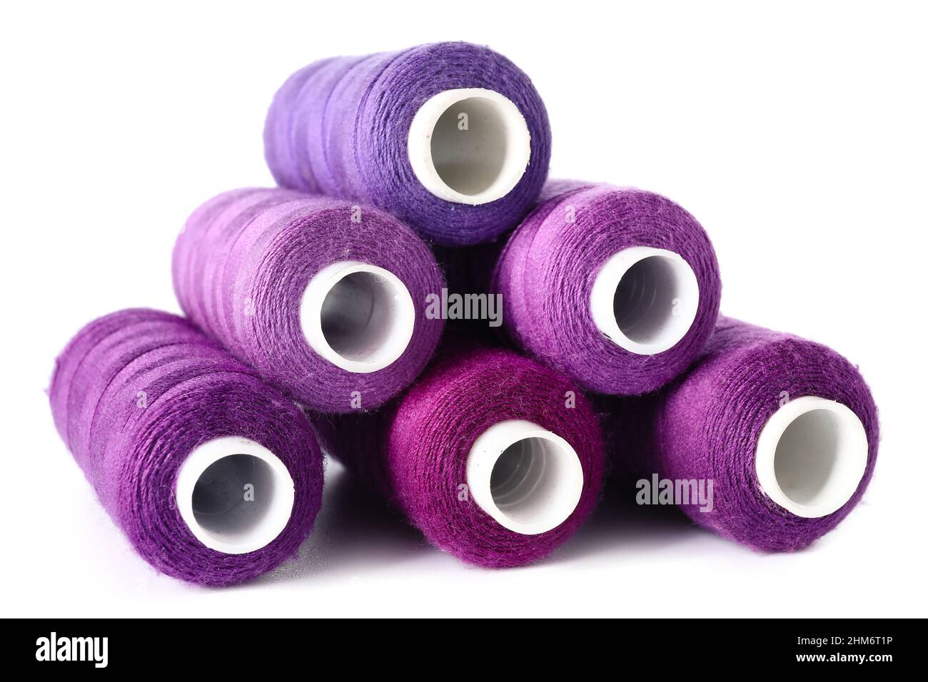 Purple sewing threads on white background Stock Photo - Alamy