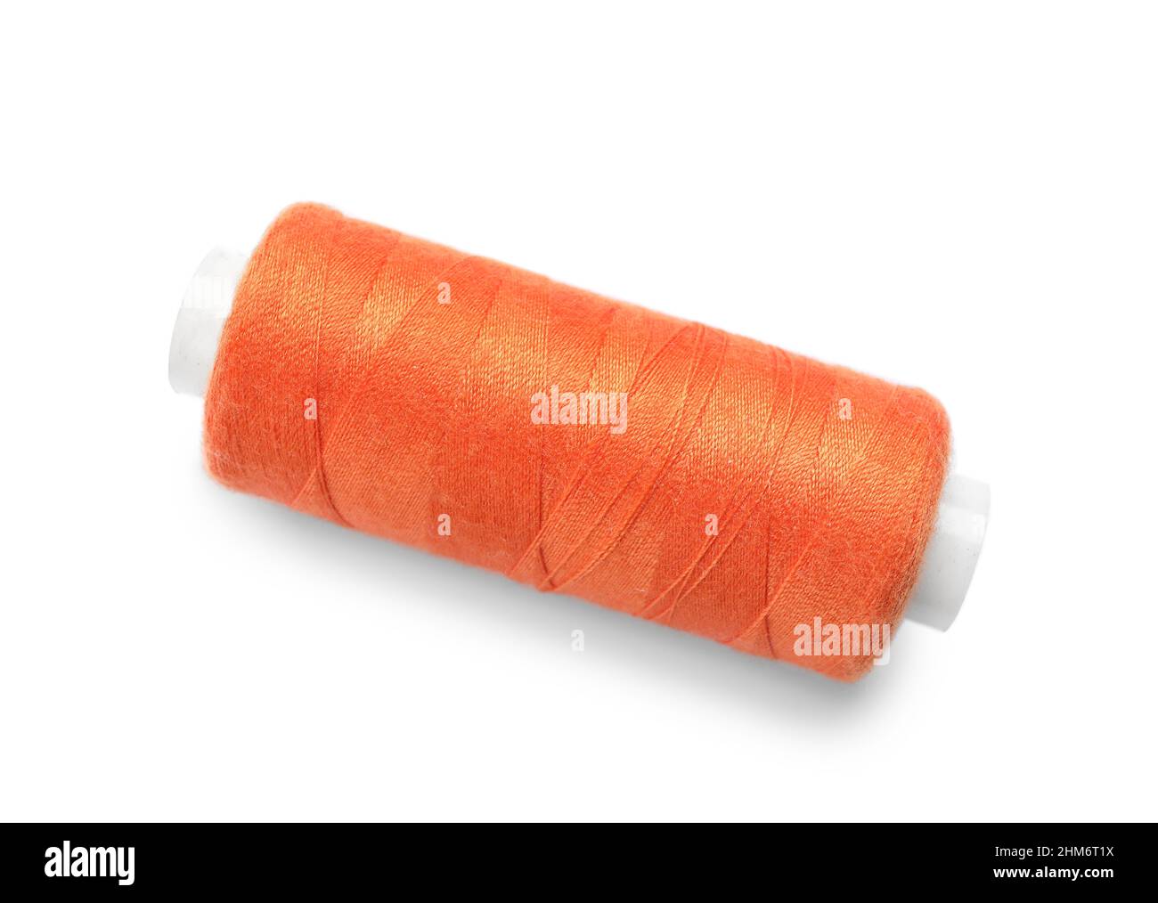 Orange sewing thread spool on white background Stock Photo - Alamy