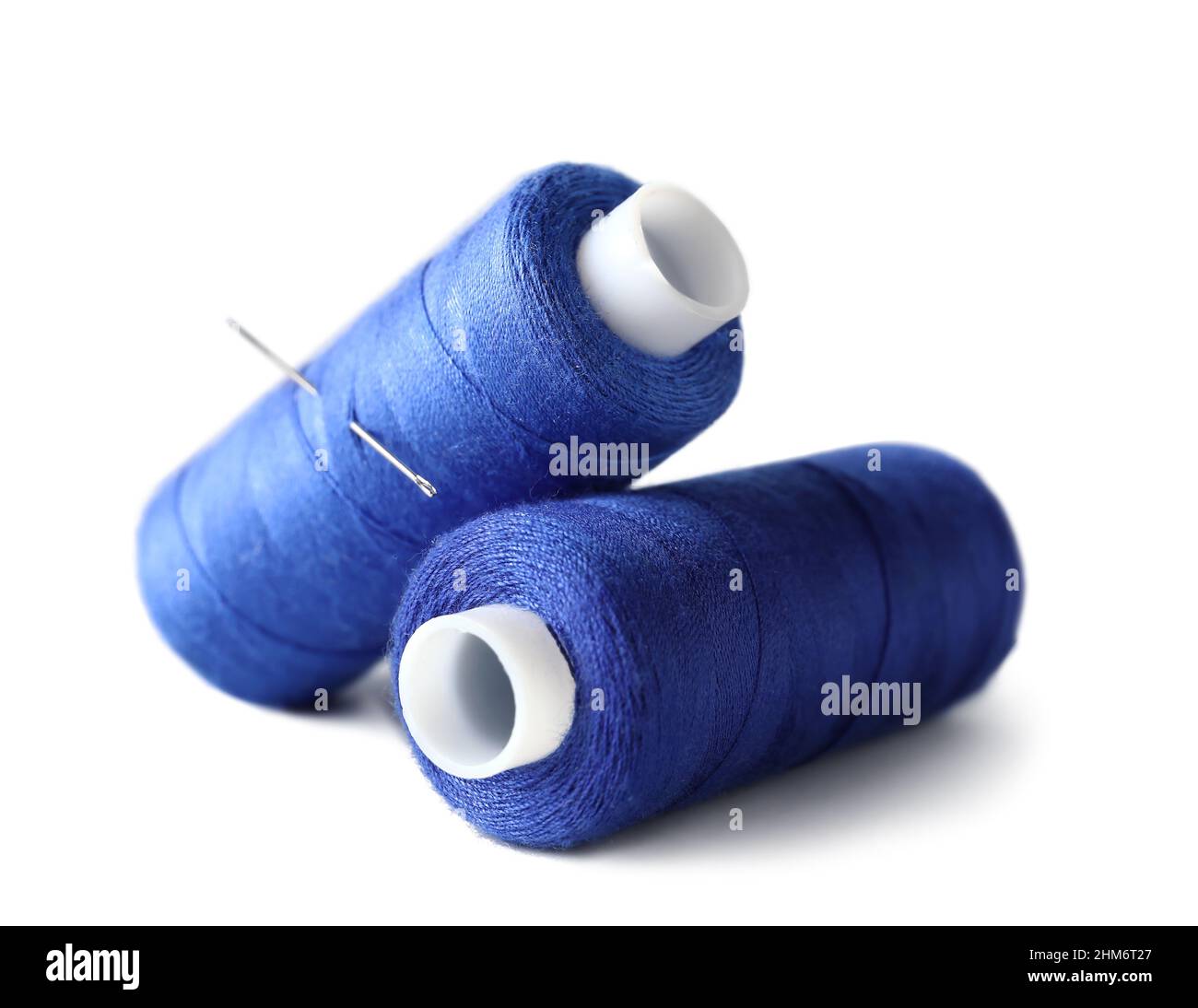 Blue sewing threads on white background Stock Photo - Alamy