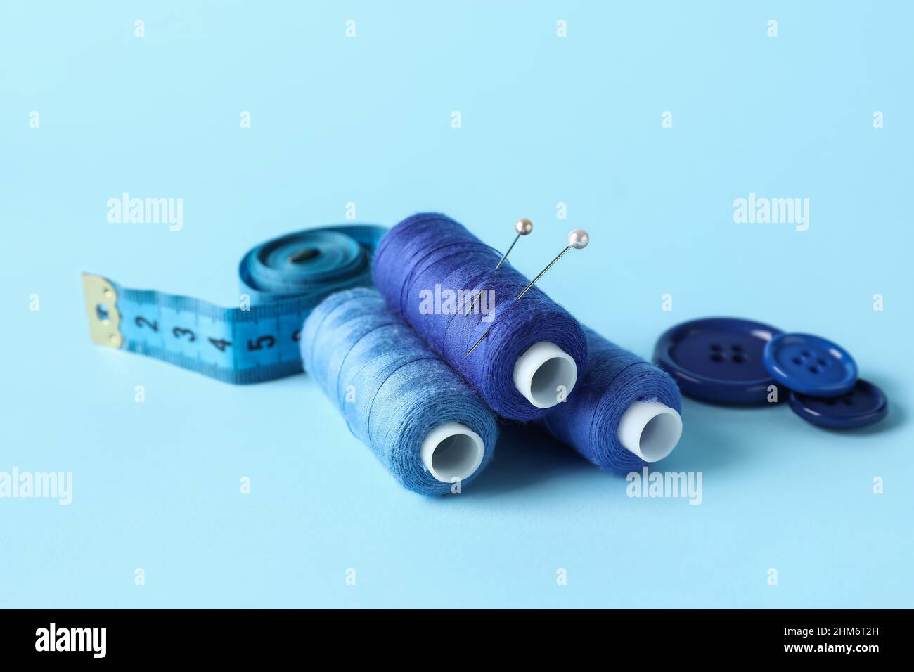 Sewing threads with measuring tape and buttons on blue background Stock ...