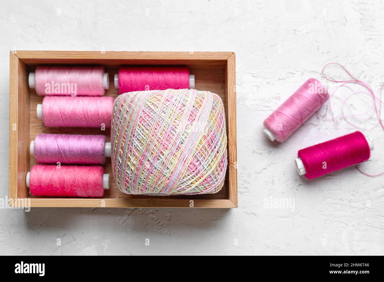 Box with sewing threads on white background Stock Photo - Alamy